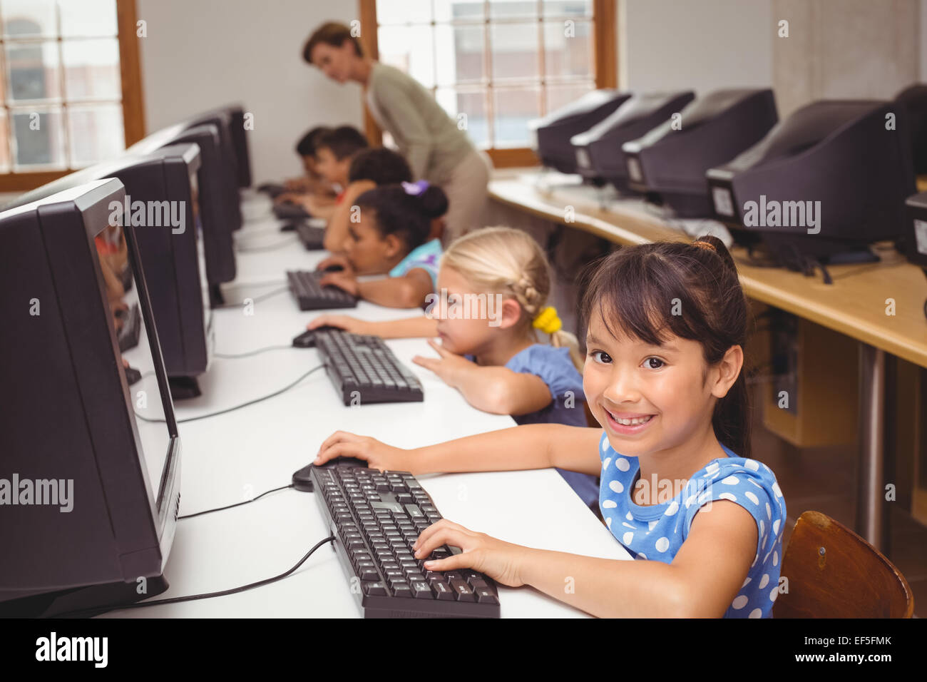 Cute pupils in computer class with teacher Stock Photo - Alamy