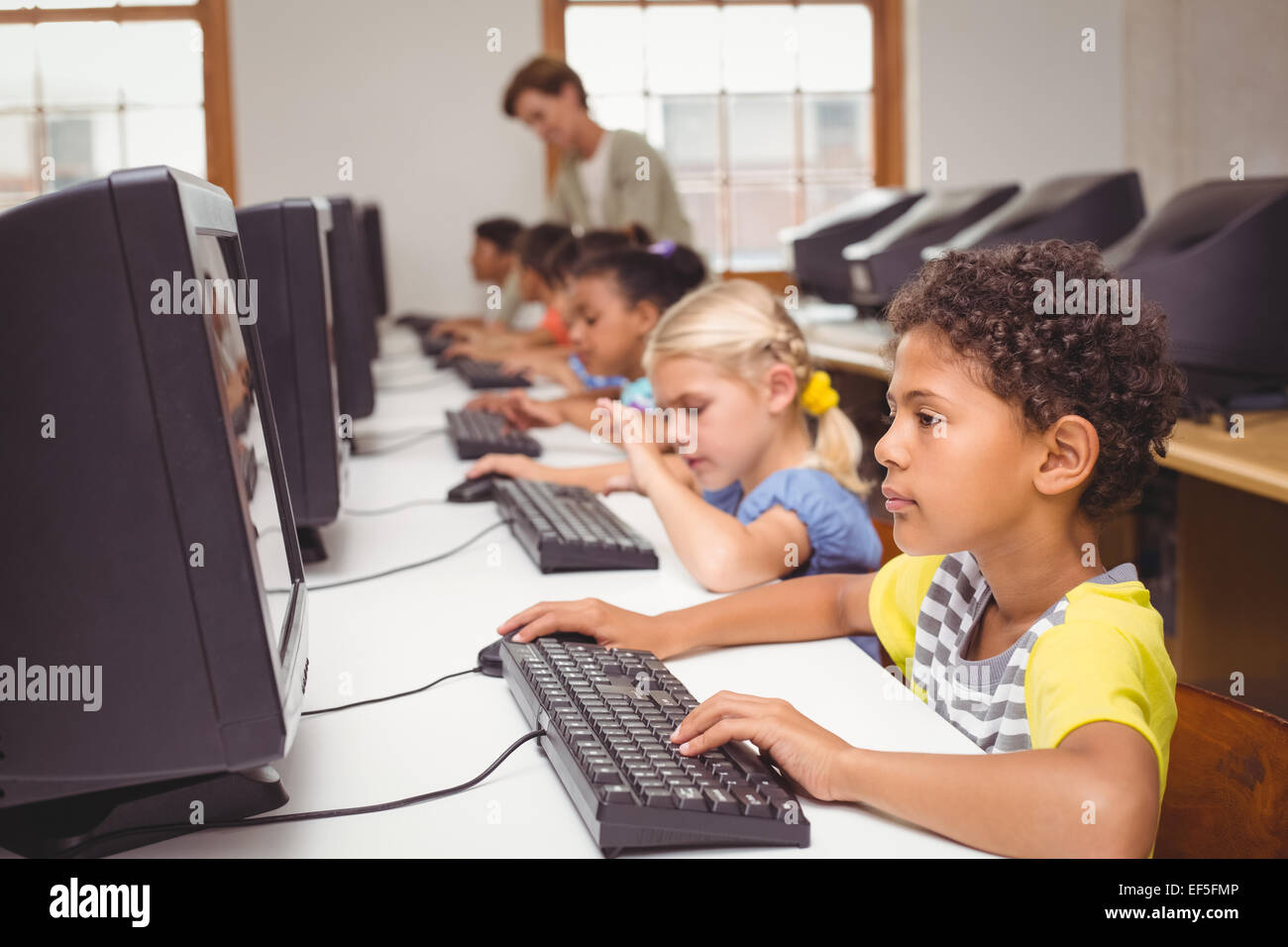 Cute pupils in computer class with teacher Stock Photo - Alamy