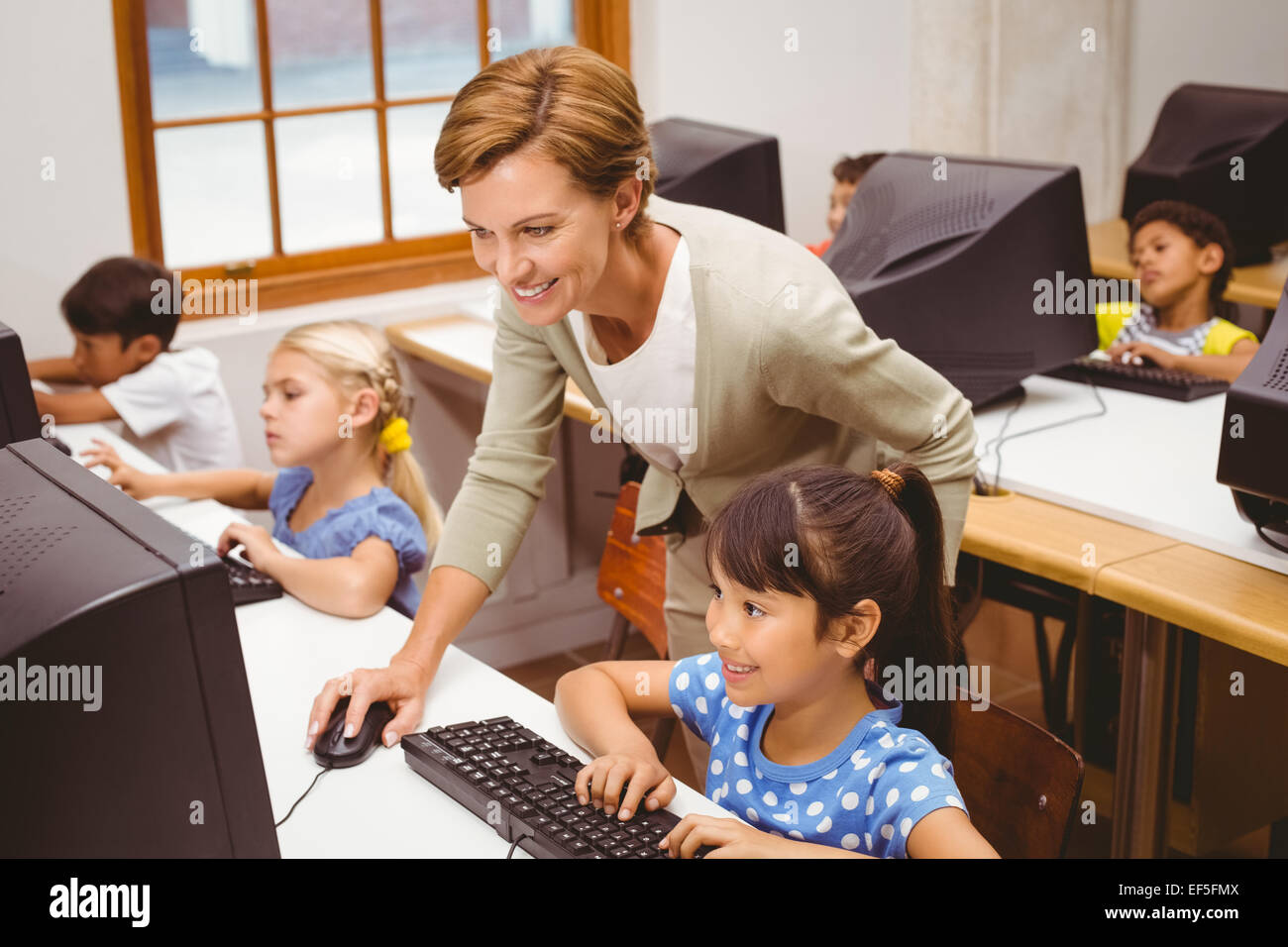Cute pupils in computer class with teacher Stock Photo - Alamy