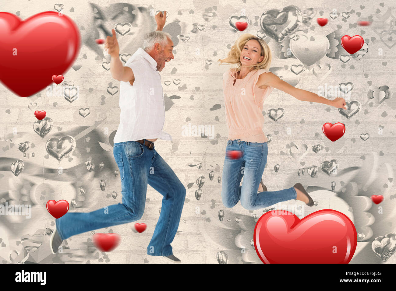 Composite image of excited couple cheering and jumping Stock Photo - Alamy