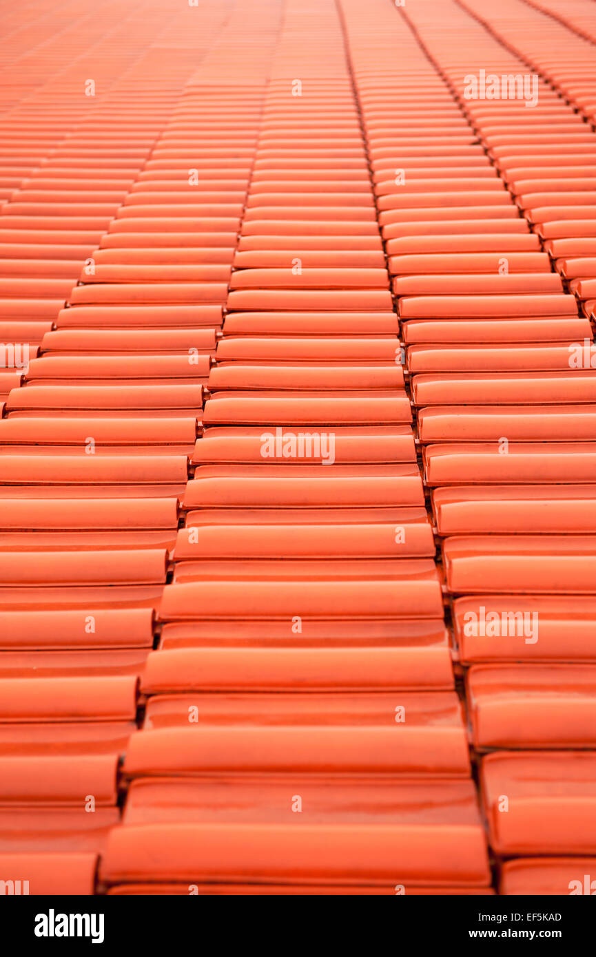 Overlapping red new tiles roof rows abstract Stock Photo - Alamy