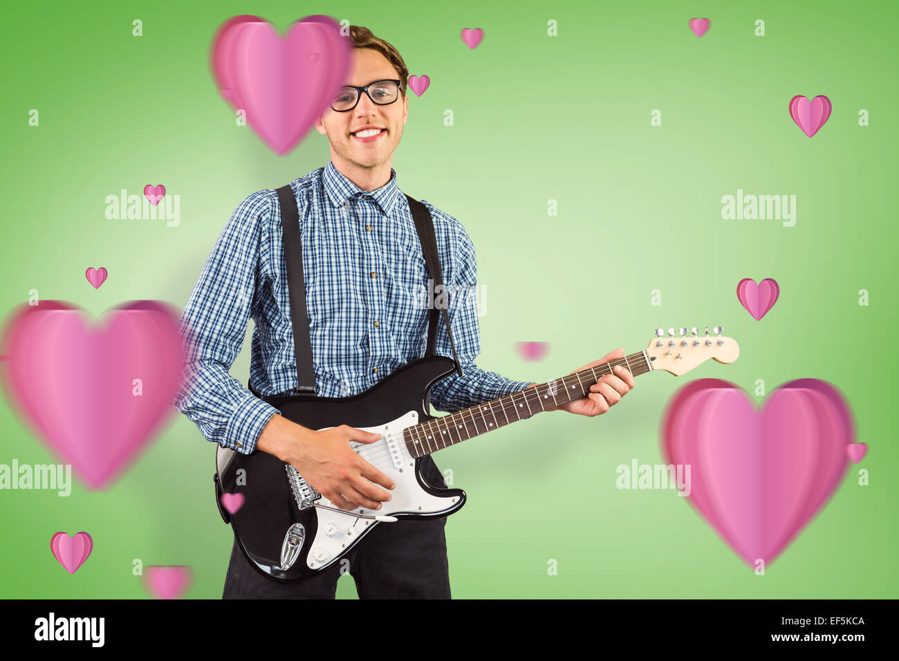 Composite image of geeky hipster playing the guitar Stock Photo - Alamy