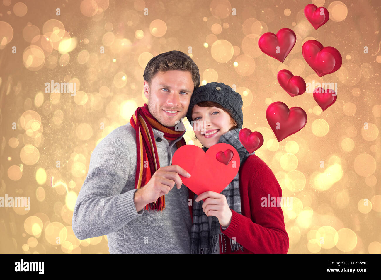 Composite image of couple holding a red heart Stock Photo - Alamy