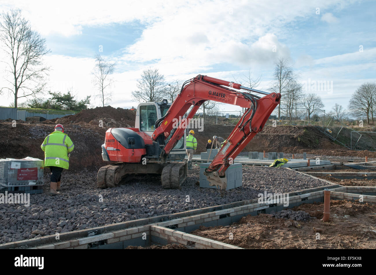 A housing building site with a digger, piles of breeze blocks and ...
