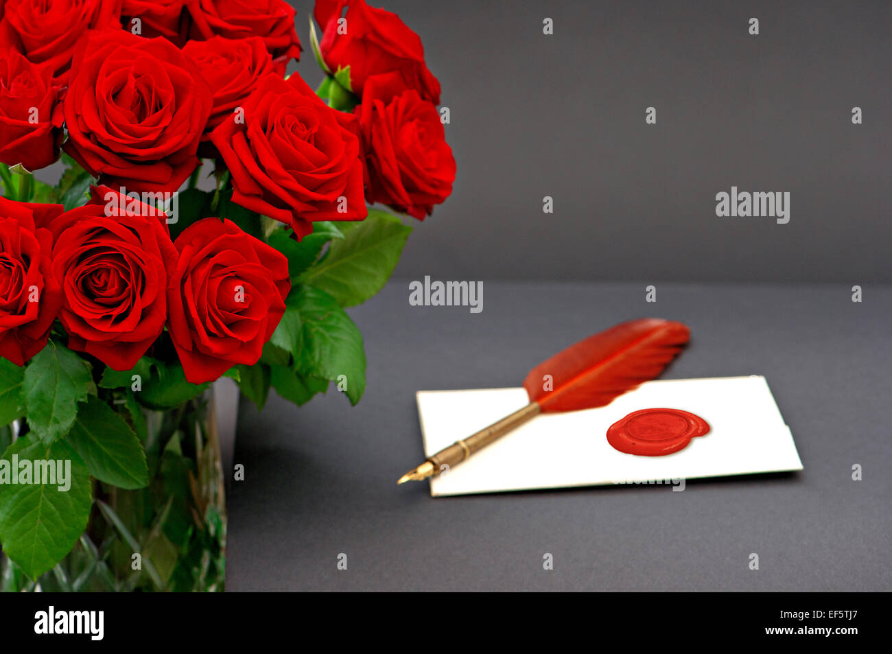 red roses and love letter on black background. festive flower ...