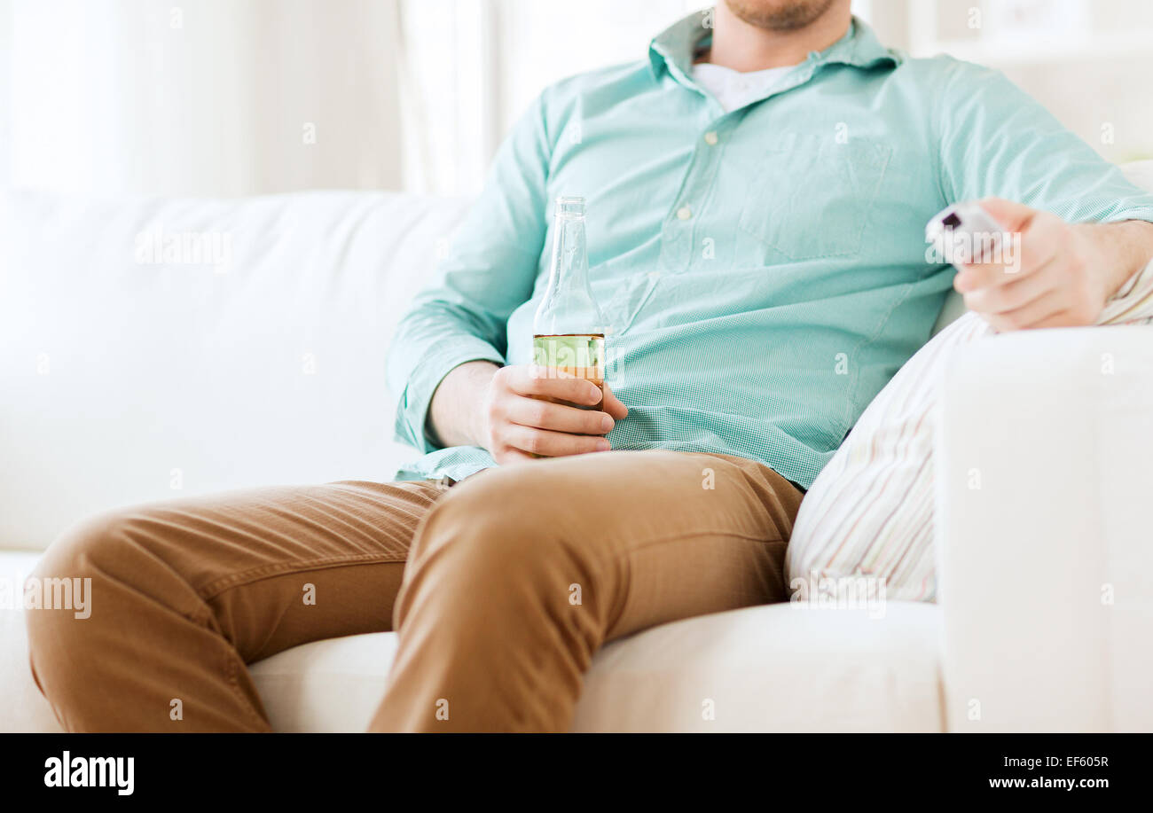 man with beer and remote control at home Stock Photo - Alamy