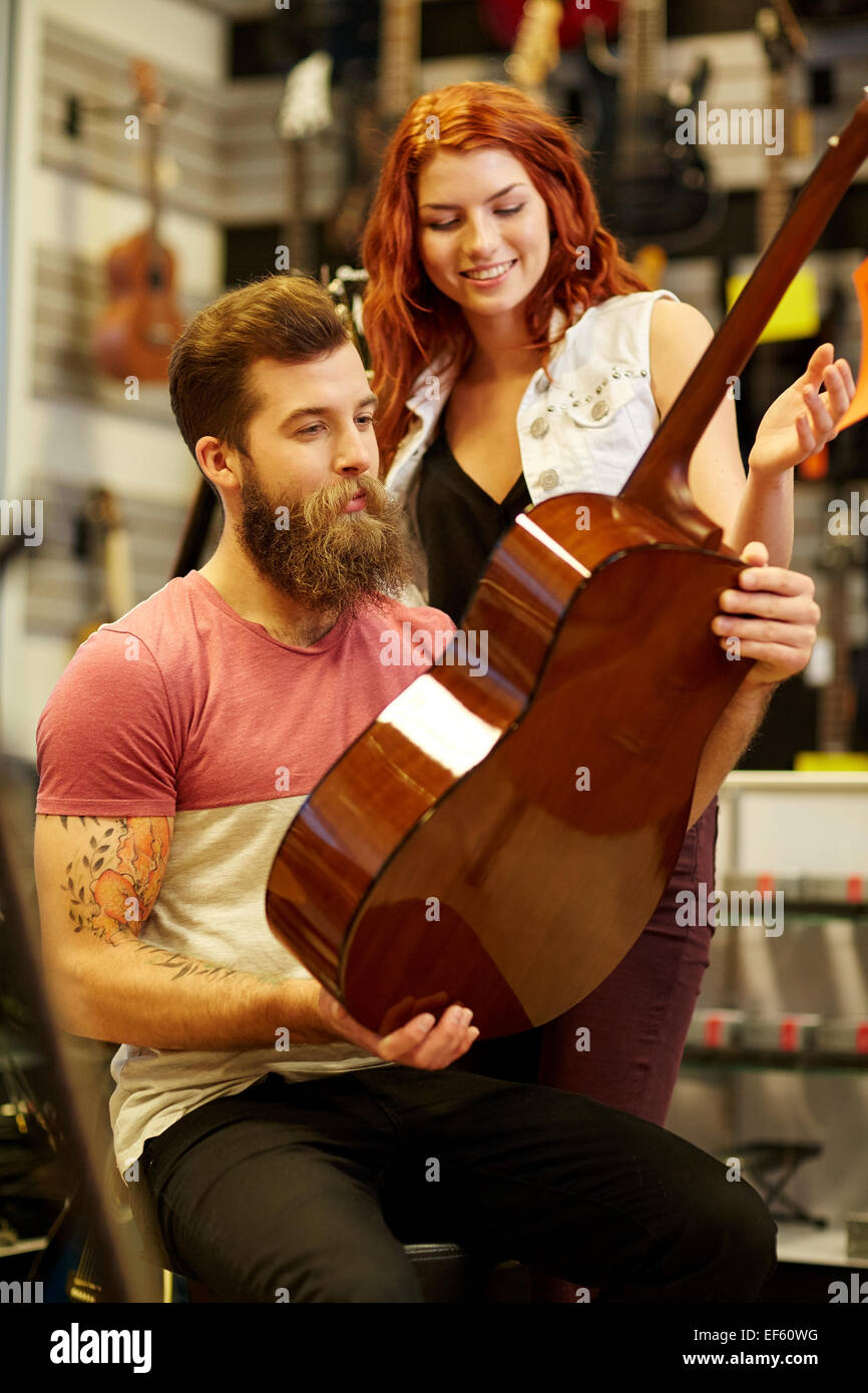 couple of musicians with guitar at music store Stock Photo - Alamy