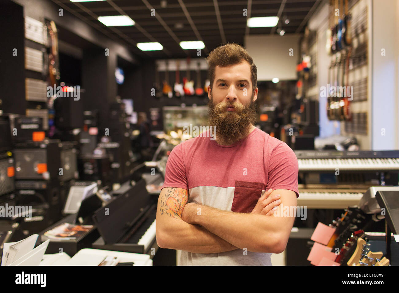 assistant or customer with beard at music store Stock Photo - Alamy
