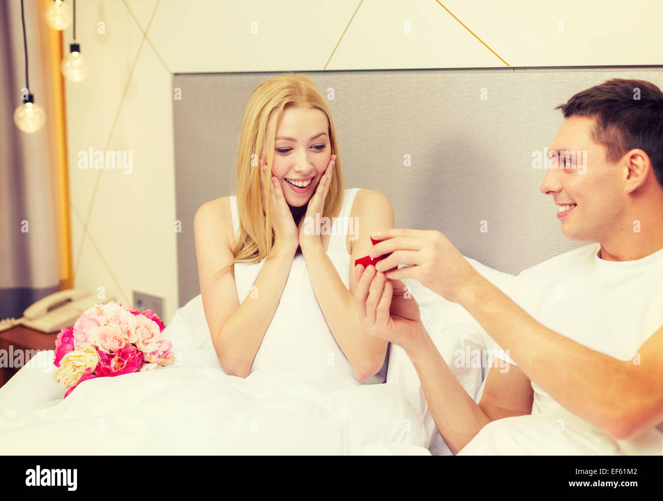 man giving woman little red box and ring in it Stock Photo - Alamy