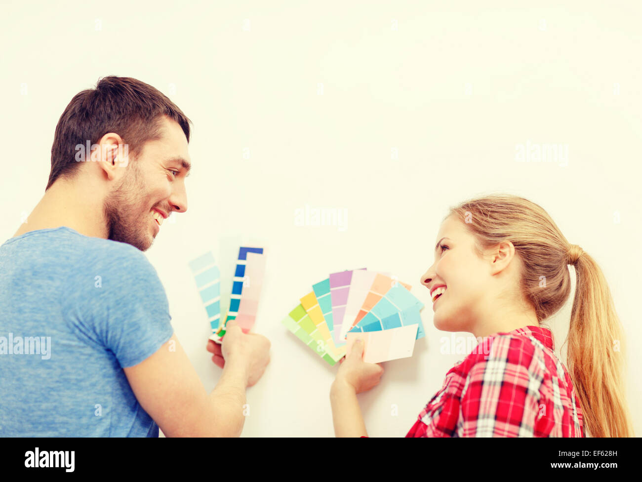 smiling couple looking at color samples at home Stock Photo - Alamy