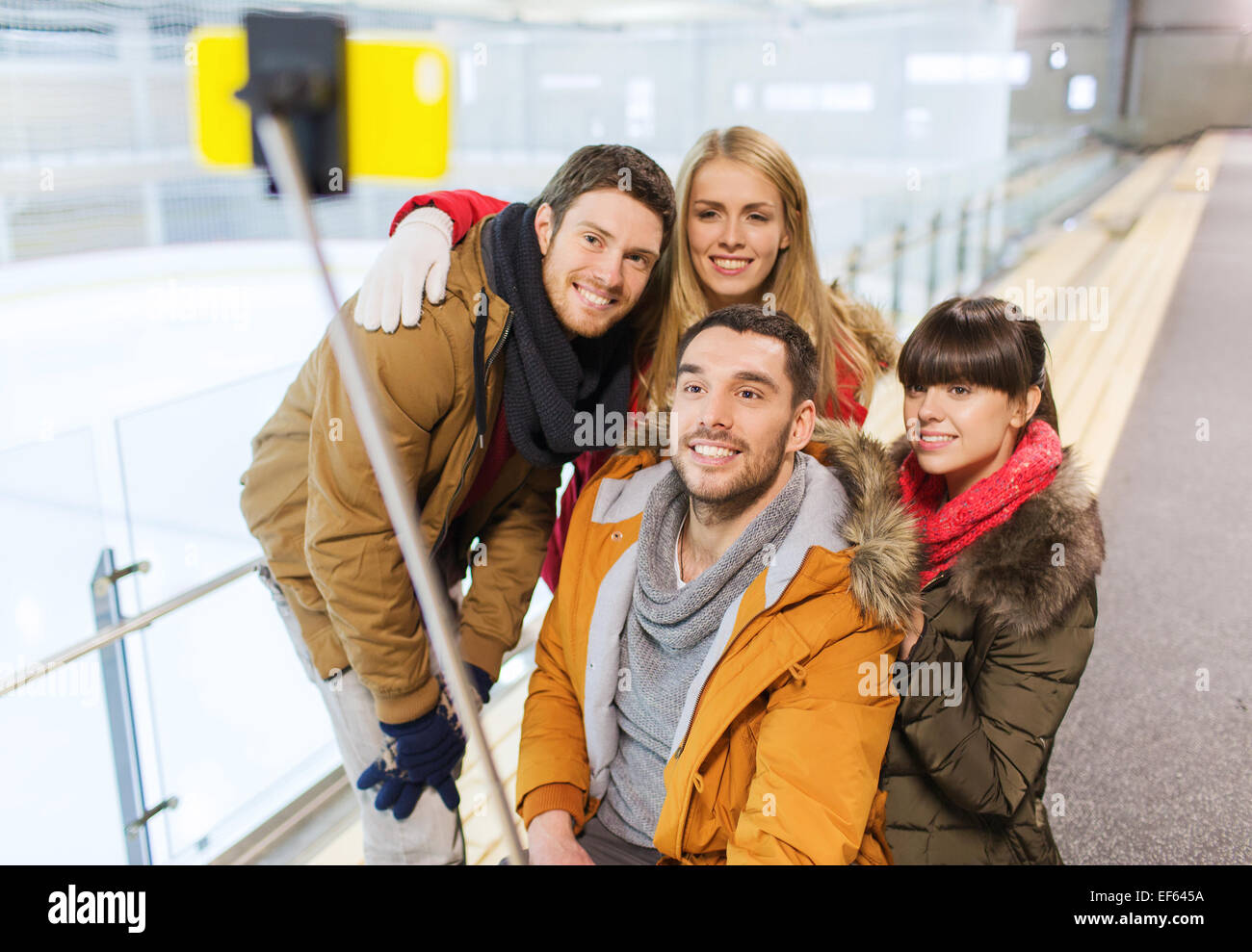 happy friends with smartphone on skating rink Stock Photo - Alamy