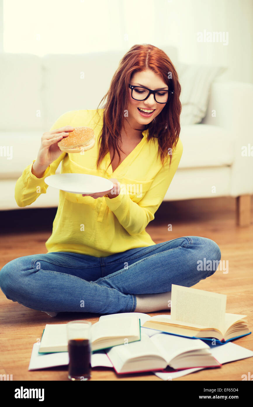 student eating hamburger and doing homework Stock Photo - Alamy