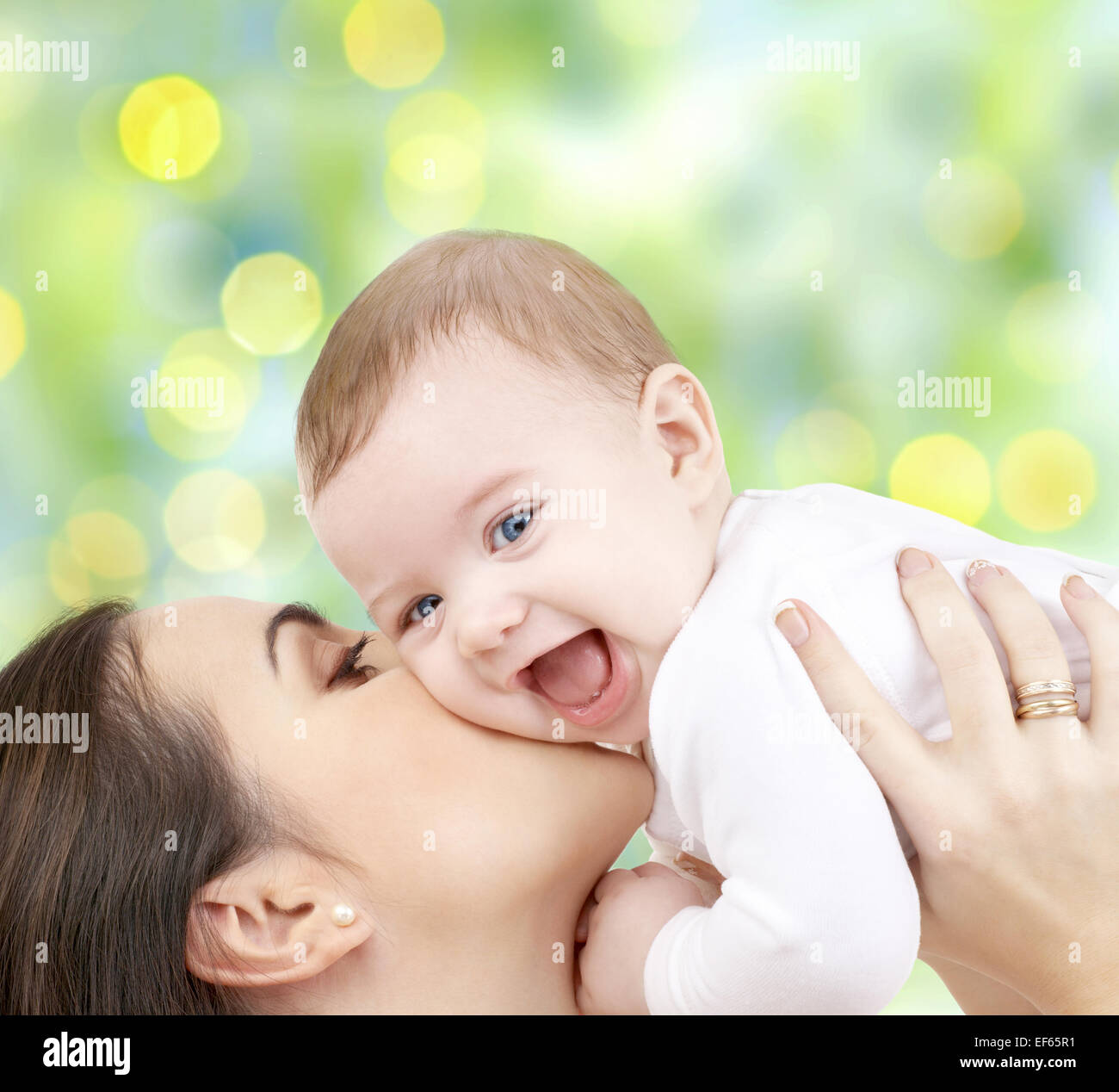 happy mother with baby over green background Stock Photo - Alamy