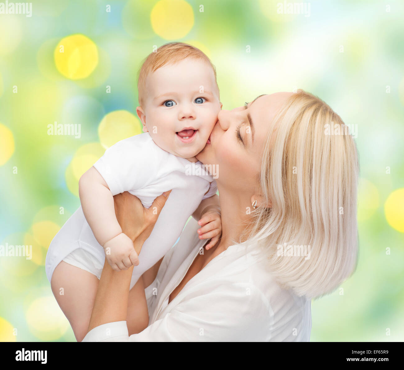happy mother with baby over green background Stock Photo - Alamy