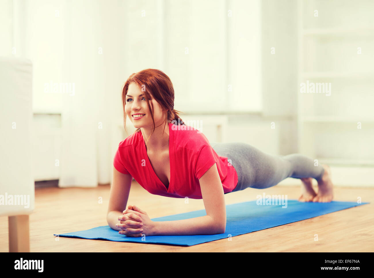 smiling redhead teenage girl doing plank at home Stock Photo - Alamy
