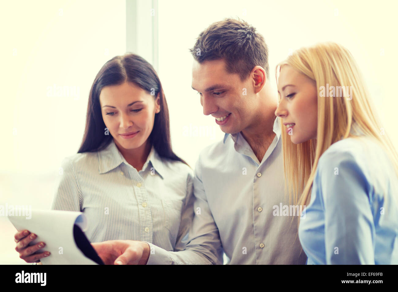 business team looking at clipboard Stock Photo - Alamy