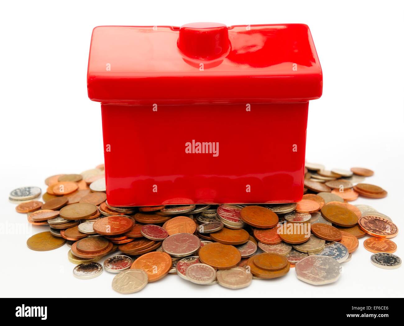 A red house money box on top of loose coins Stock Photo - Alamy