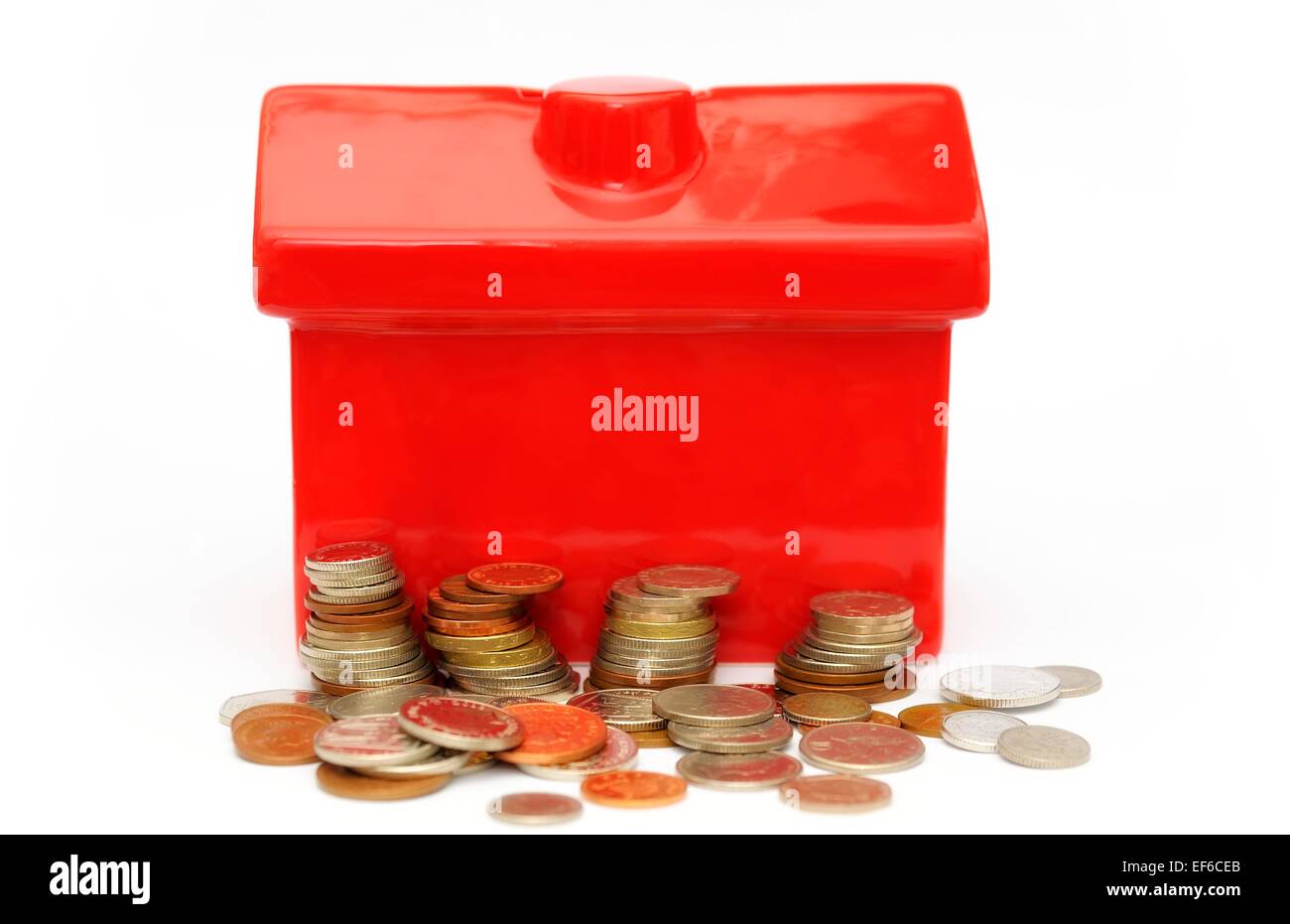A red house money box with small stacks of coins in front Stock Photo ...