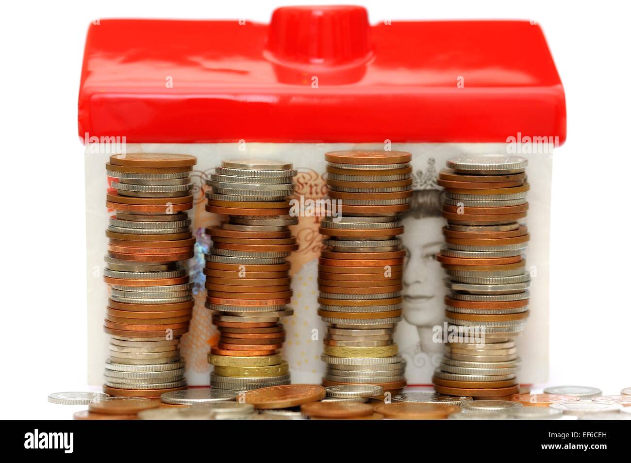 A red house money box with stacks of coins in front Stock Photo - Alamy