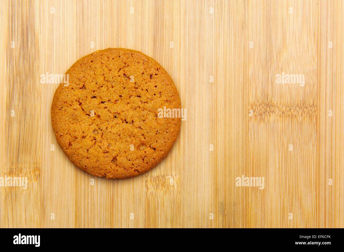 A single ginger biscuit on a wooden background Stock Photo - Alamy