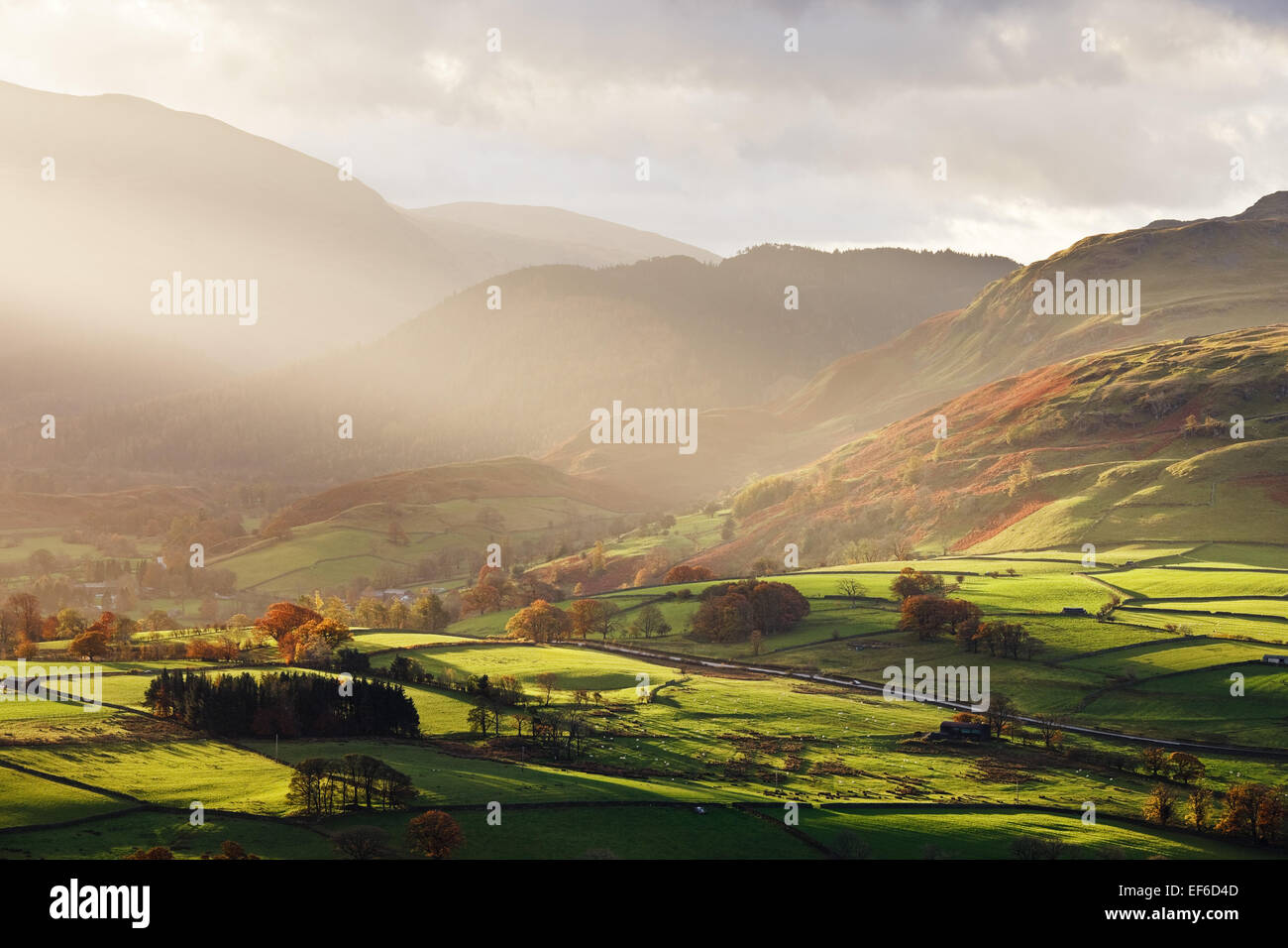 Golden Crepuscular rays illuminates the rugged landscape of Cumbria ...