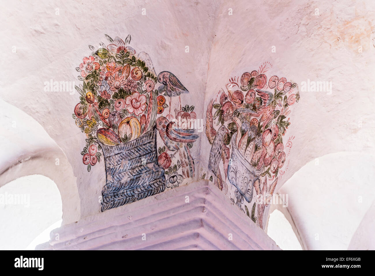 Colourful fresco paintings, birds and fruit, at the top of a column in ...
