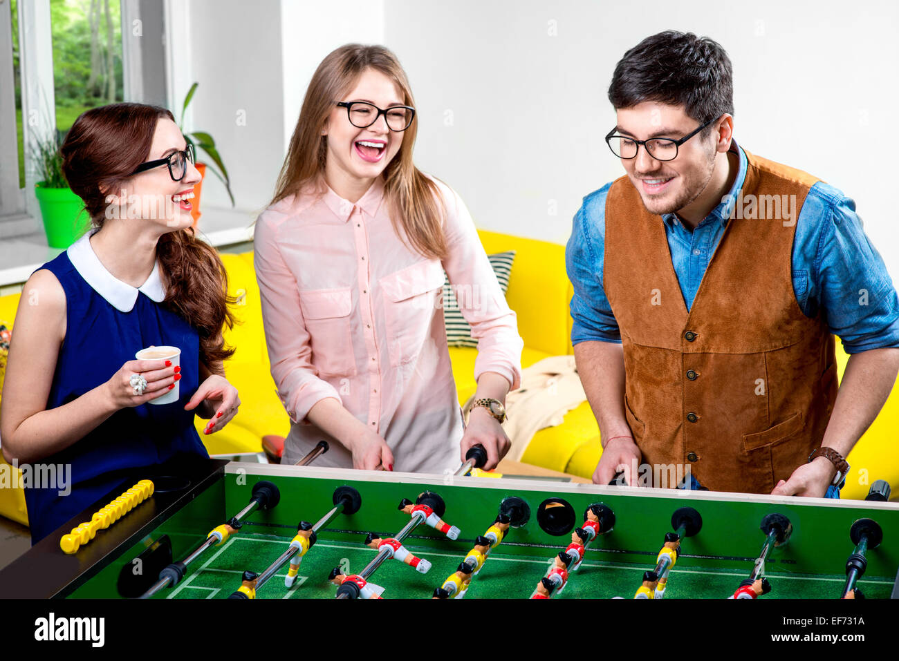 Friends playing table football Stock Photo - Alamy