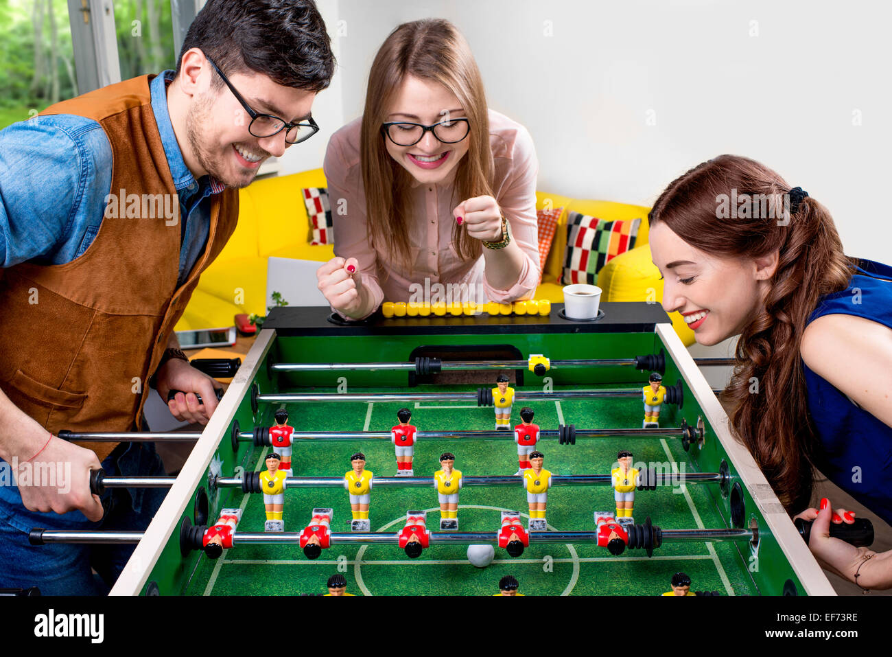 Friends playing table football Stock Photo - Alamy