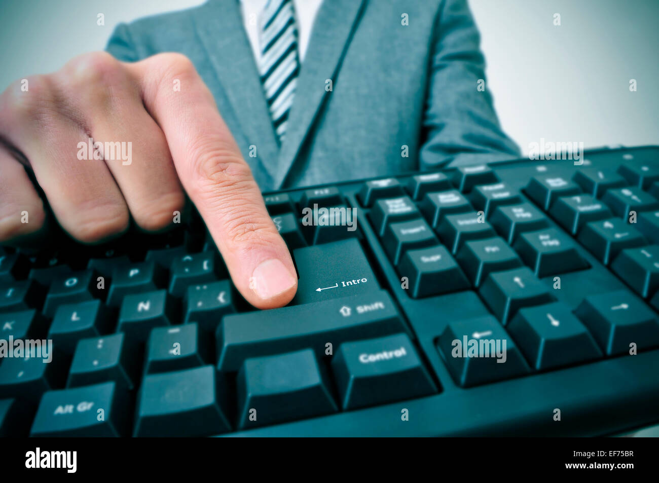 closeup of a businessman pressing the inter key of a computer keyboard ...