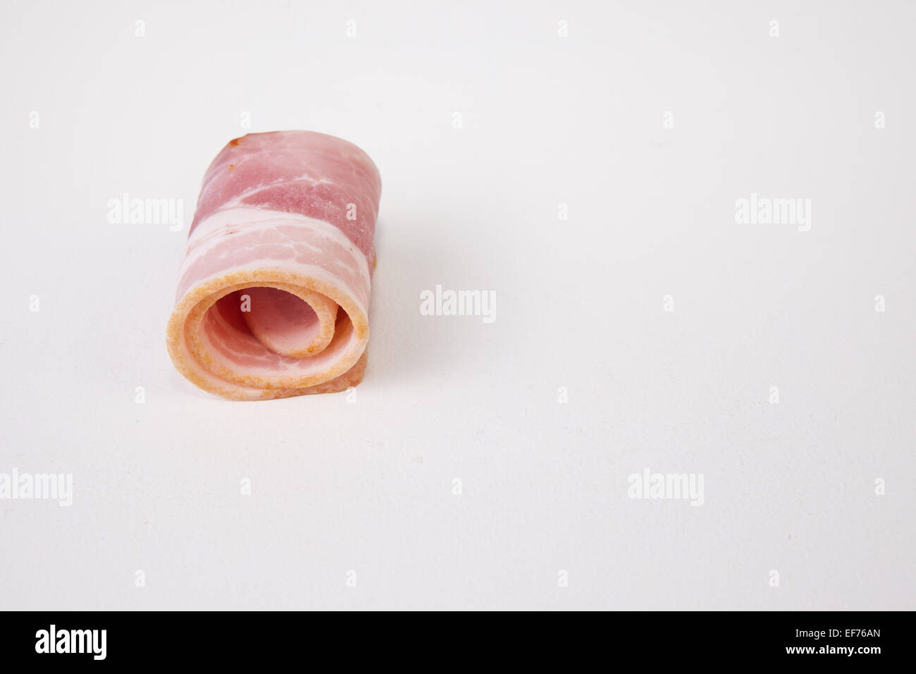Rolled raw bacon slice isolated on white background Stock Photo - Alamy