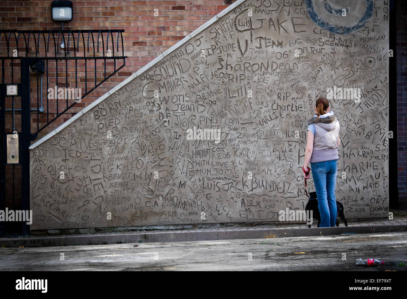 Girl with dog in Barton,a poor area of Oxford,UK and graffiti on wall ...