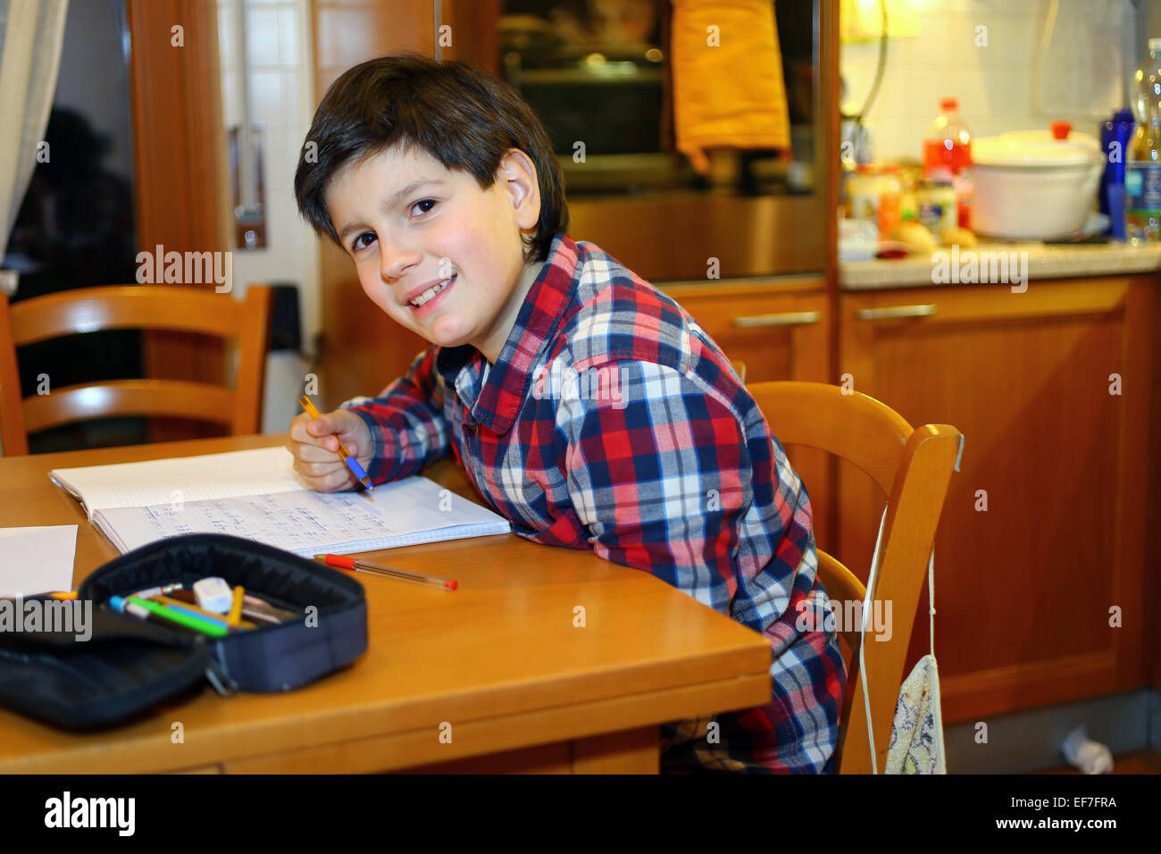 young smiling boy does homework at his home Stock Photo - Alamy