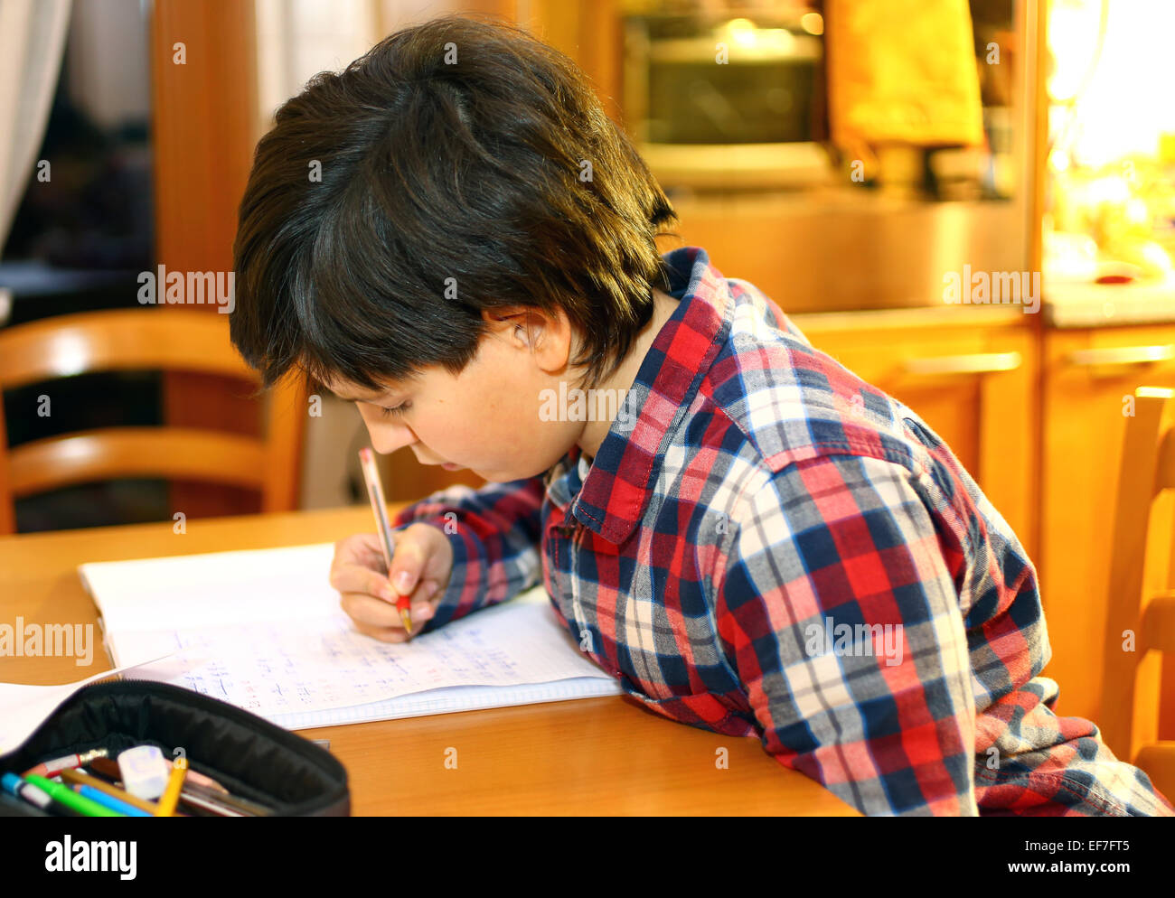 young boy writes on his notebook at home 14 Stock Photo - Alamy