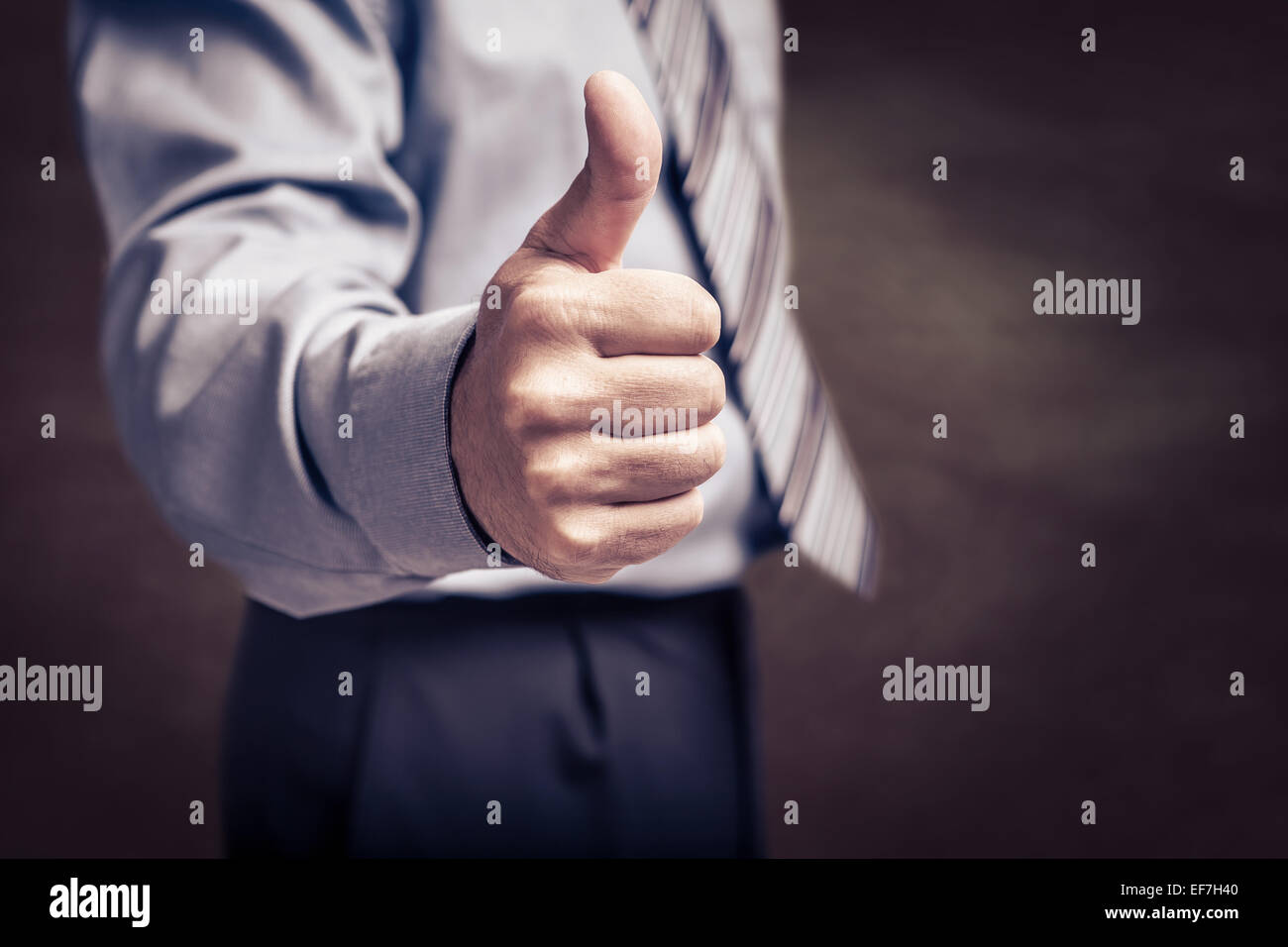 a businessman stick one's thumb in the air Stock Photo - Alamy