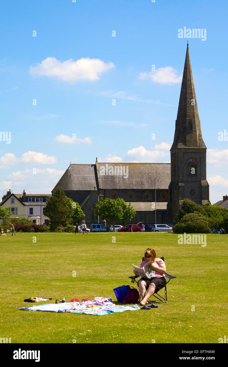 Woman sitting reading enjoying the sun on Silloth Green with Christ ...