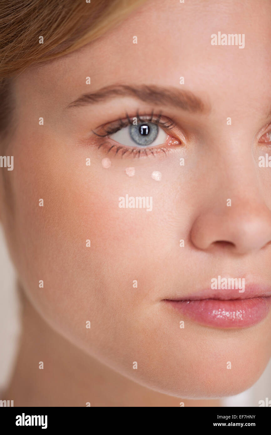 Beautiful woman applying concealer Stock Photo - Alamy