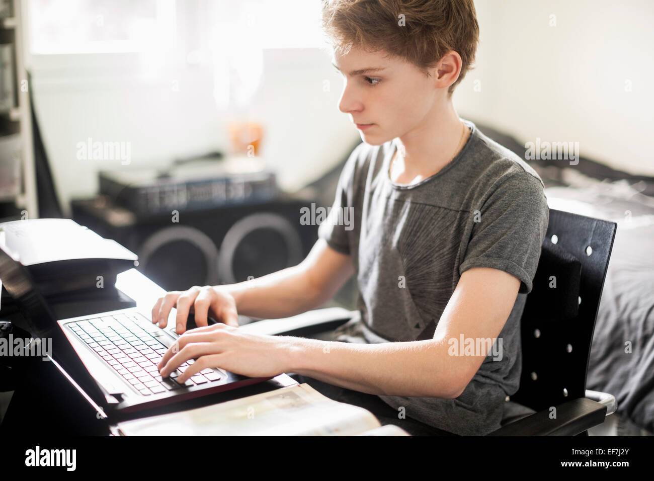 Teenage boy typing on laptop Stock Photo - Alamy