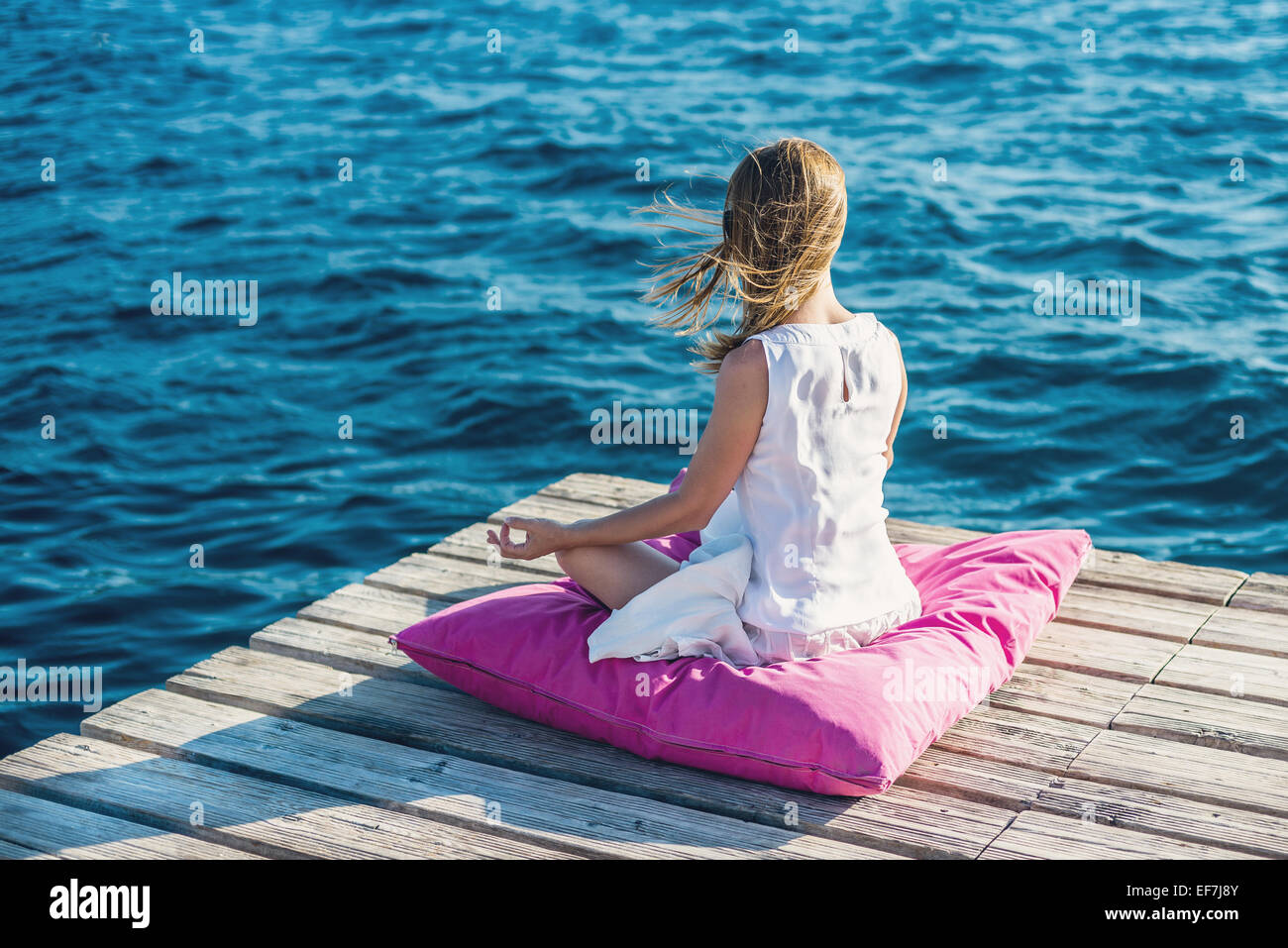 Woman meditating at the sea Stock Photo - Alamy