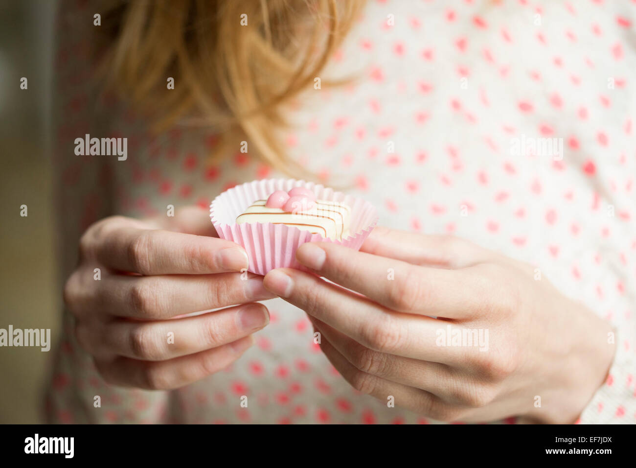 Woman eating a cupcake Stock Photo - Alamy