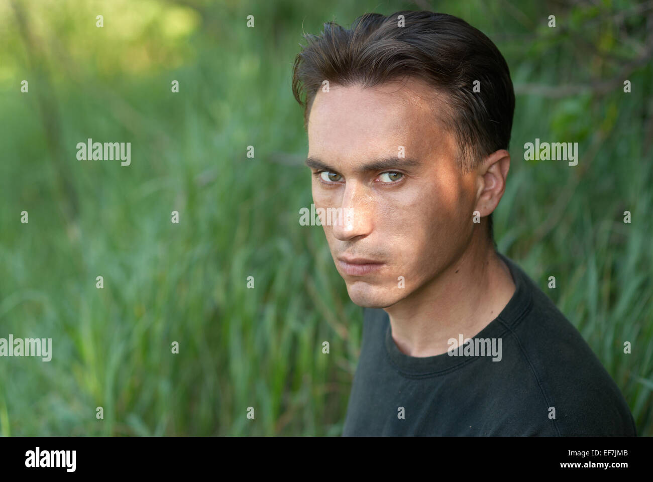 Man's portrait in the green grass background Stock Photo - Alamy