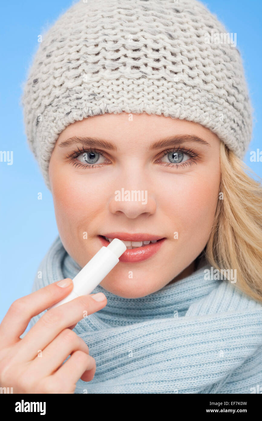 Beautiful woman applying lip balm Stock Photo - Alamy