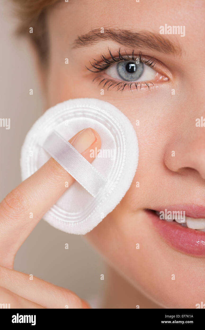 Beautiful woman applying powder puff Stock Photo - Alamy