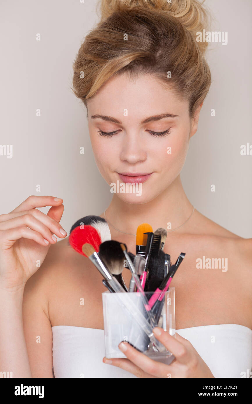 Beautiful woman holding assorted makeup brushes Stock Photo - Alamy