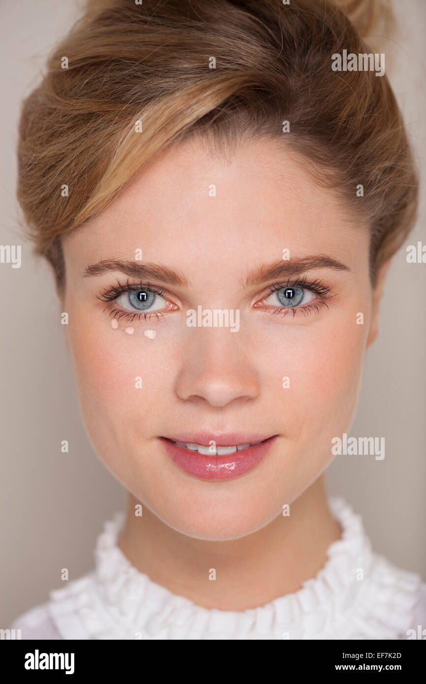 Beautiful woman applying concealer Stock Photo - Alamy