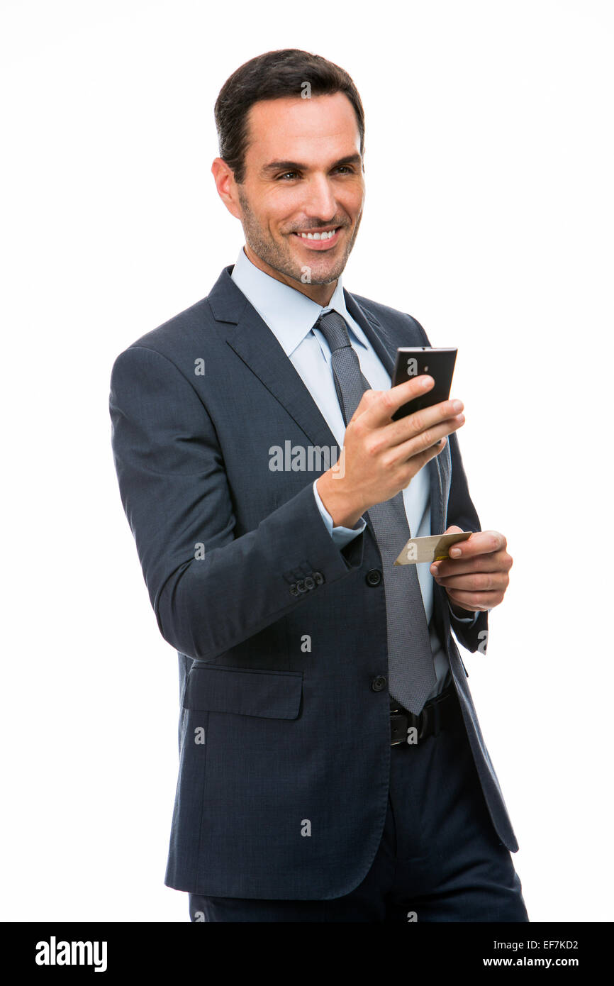 Half length portrait of a smiling businessman holding mobile phone and ...