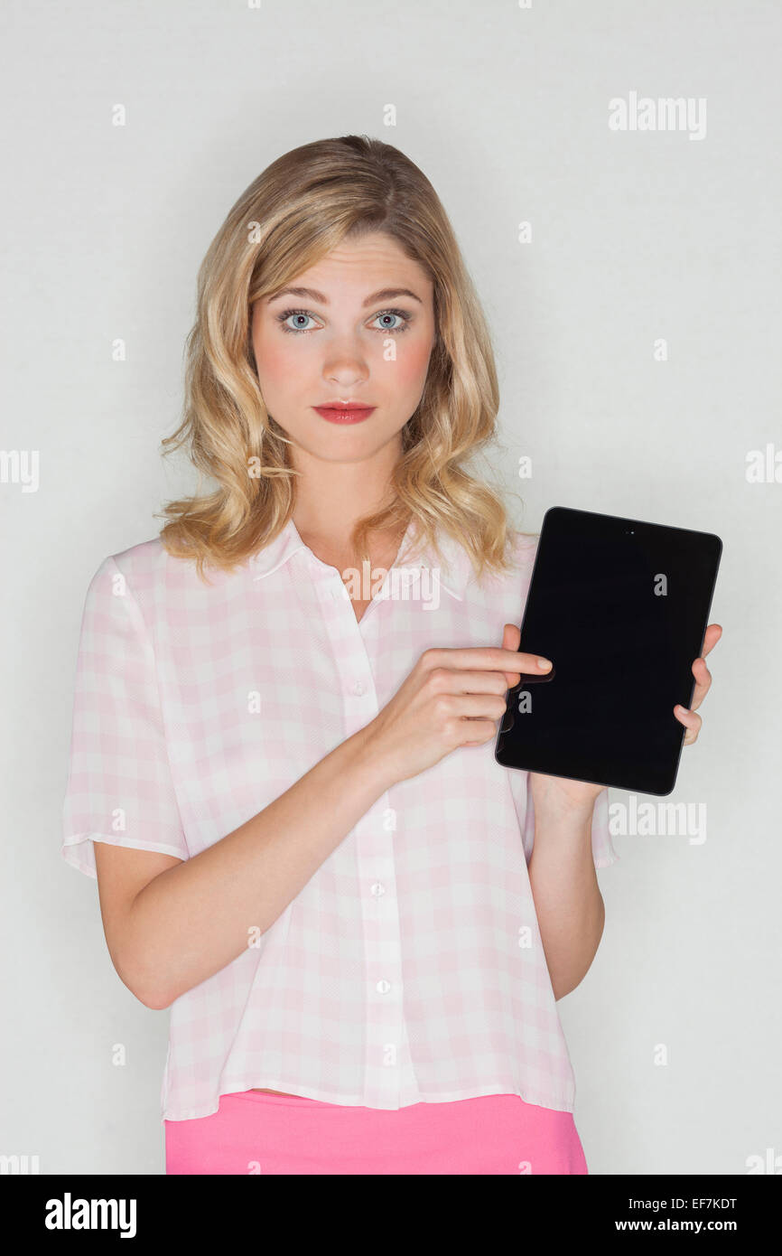 Portrait of a beautiful woman showing a digital tablet Stock Photo - Alamy