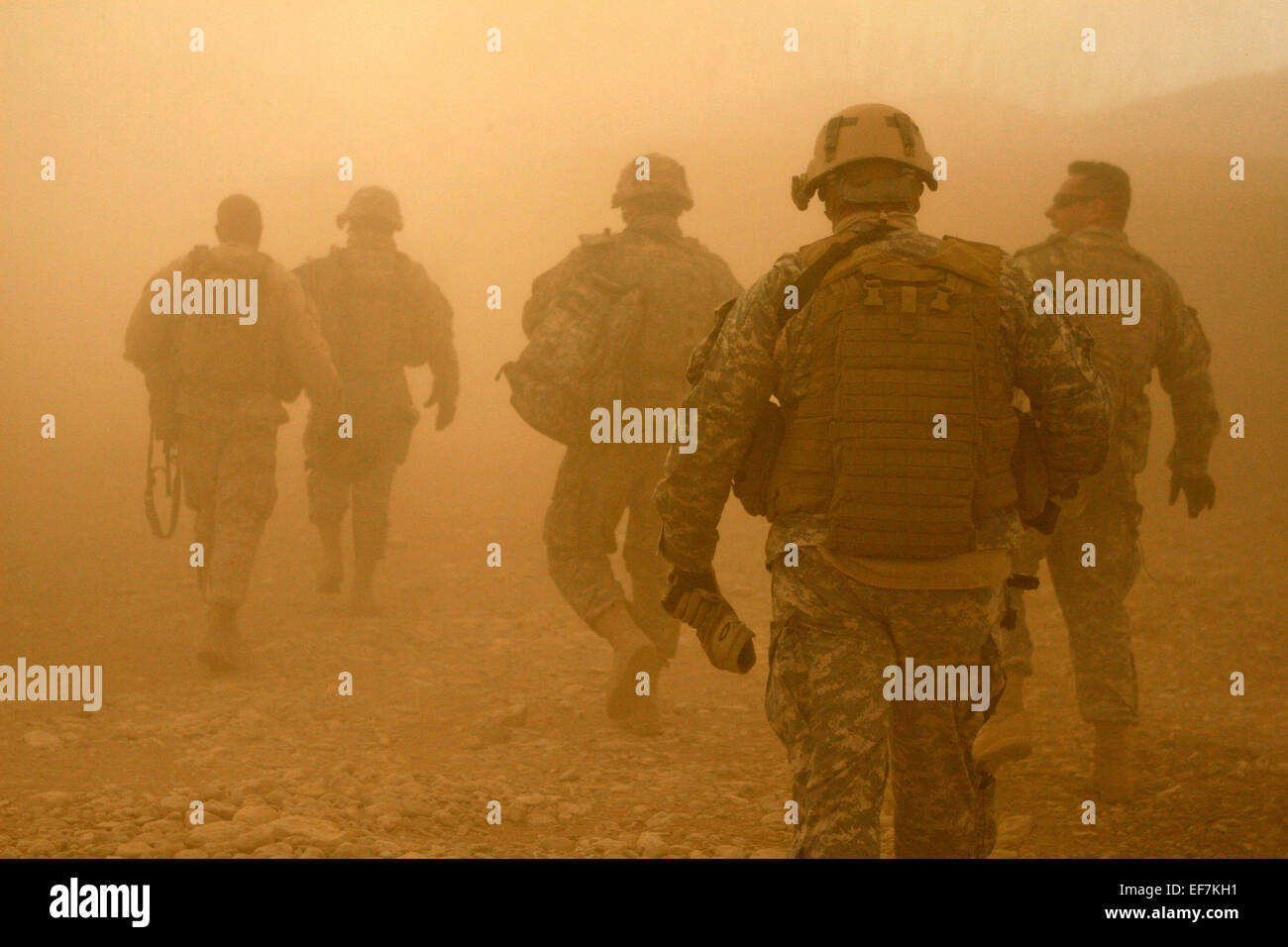 US Marines walk through rotor wash from a UH-60 Blackhawk Helicopter ...