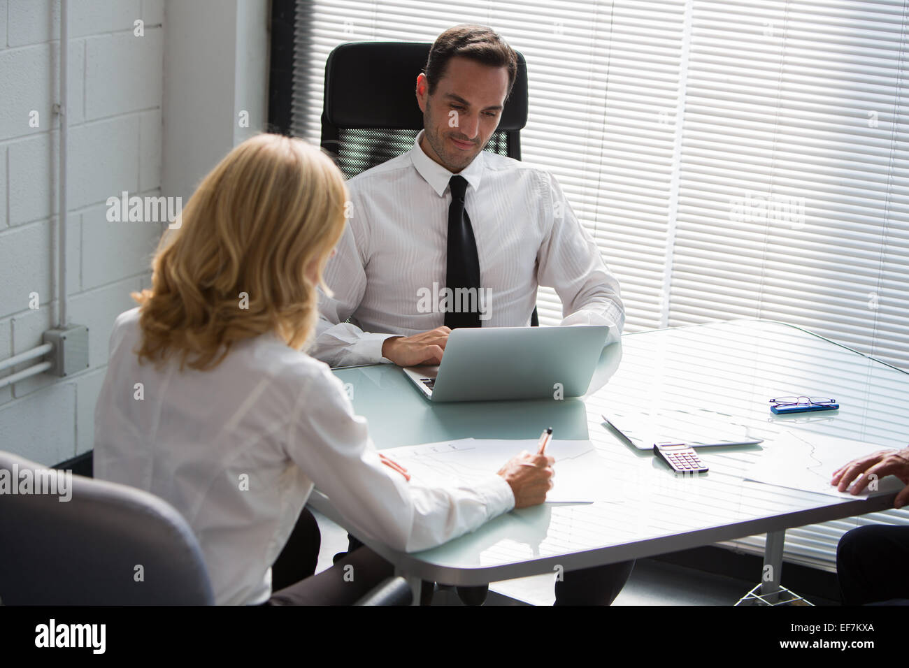 Two businesspeople having a meeting in the office using laptop computer ...