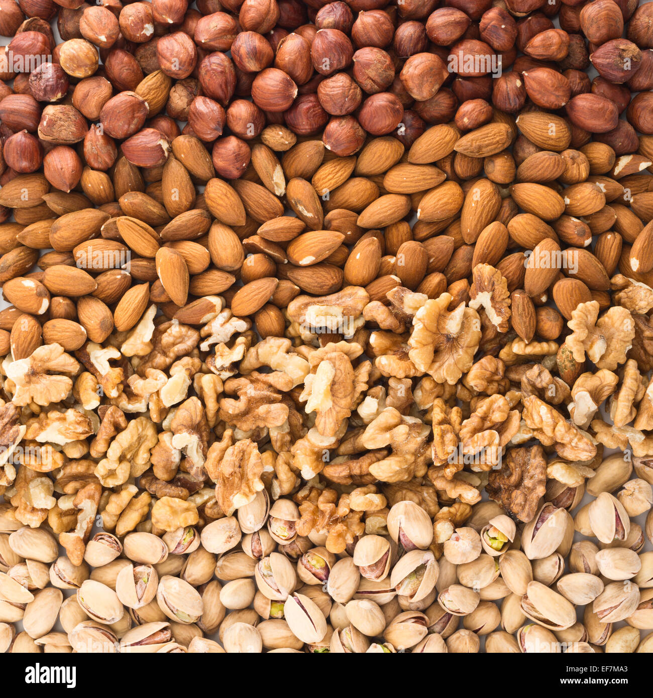 Surface covered with different nuts Stock Photo - Alamy