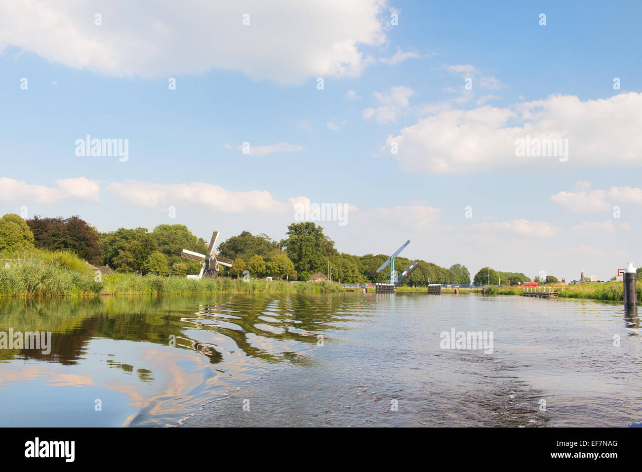 Dutch windmill in landscape with river Stock Photo - Alamy
